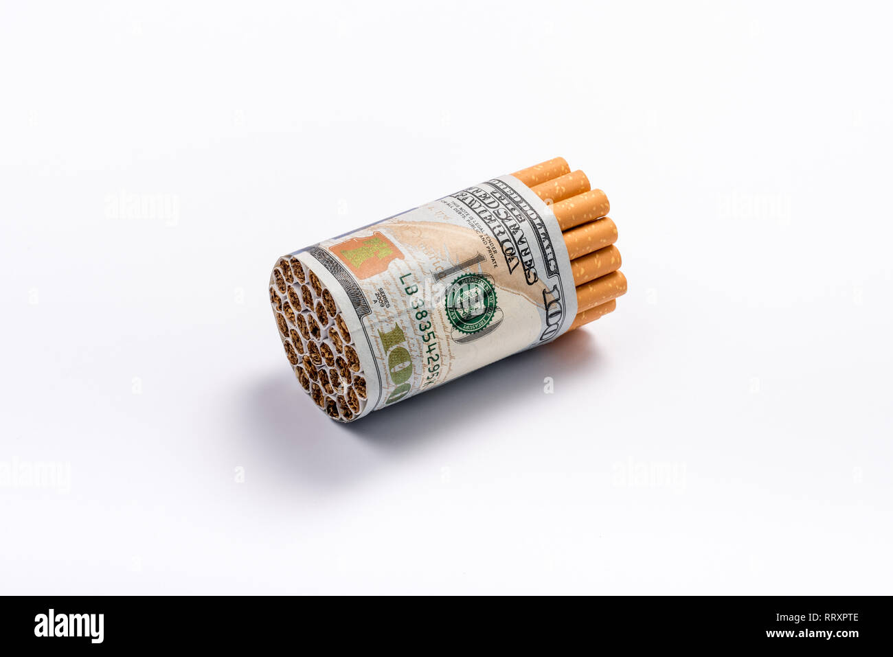 Smoking and money cost. Cigarettes wrapped in hundred dollars banknotes ...