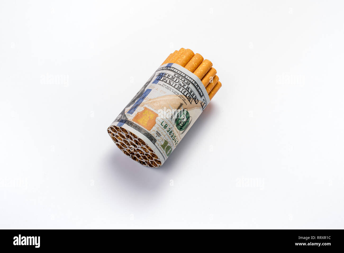 Smoking and money cost. Cigarettes wrapped in hundred dollars banknotes ...