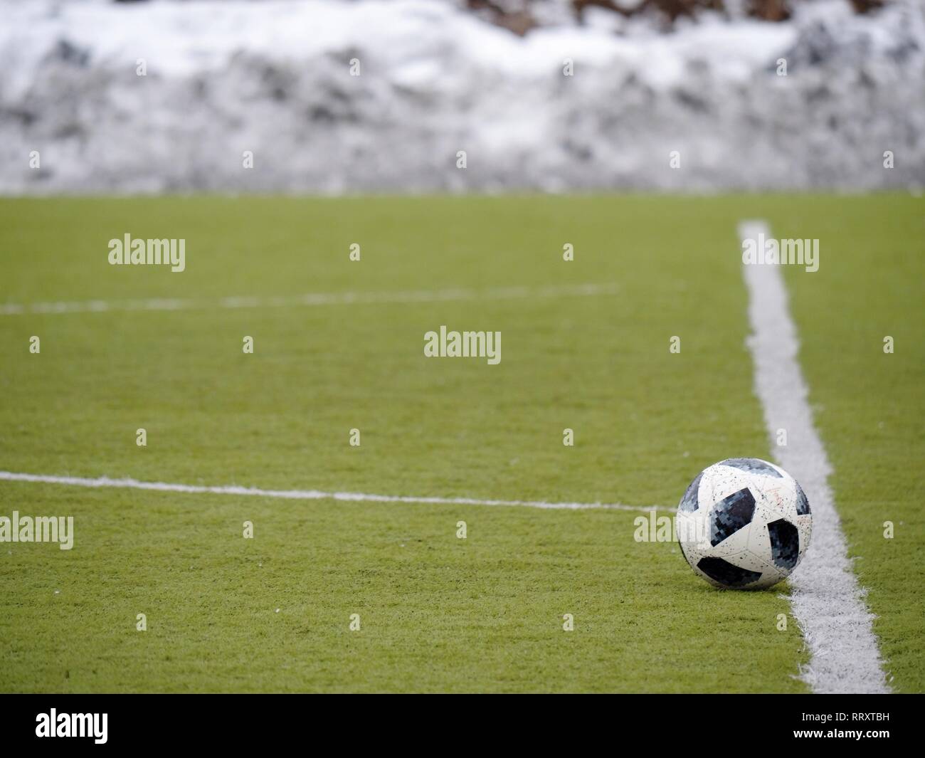 Winter football playground with plastic grass, snow pilled around field ...