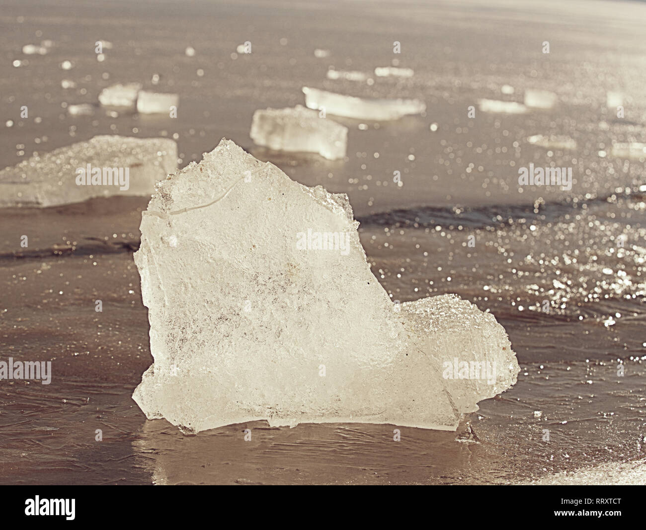 Ice floe at frozen lake surface with reflection. Bubbles frozen in thin ...
