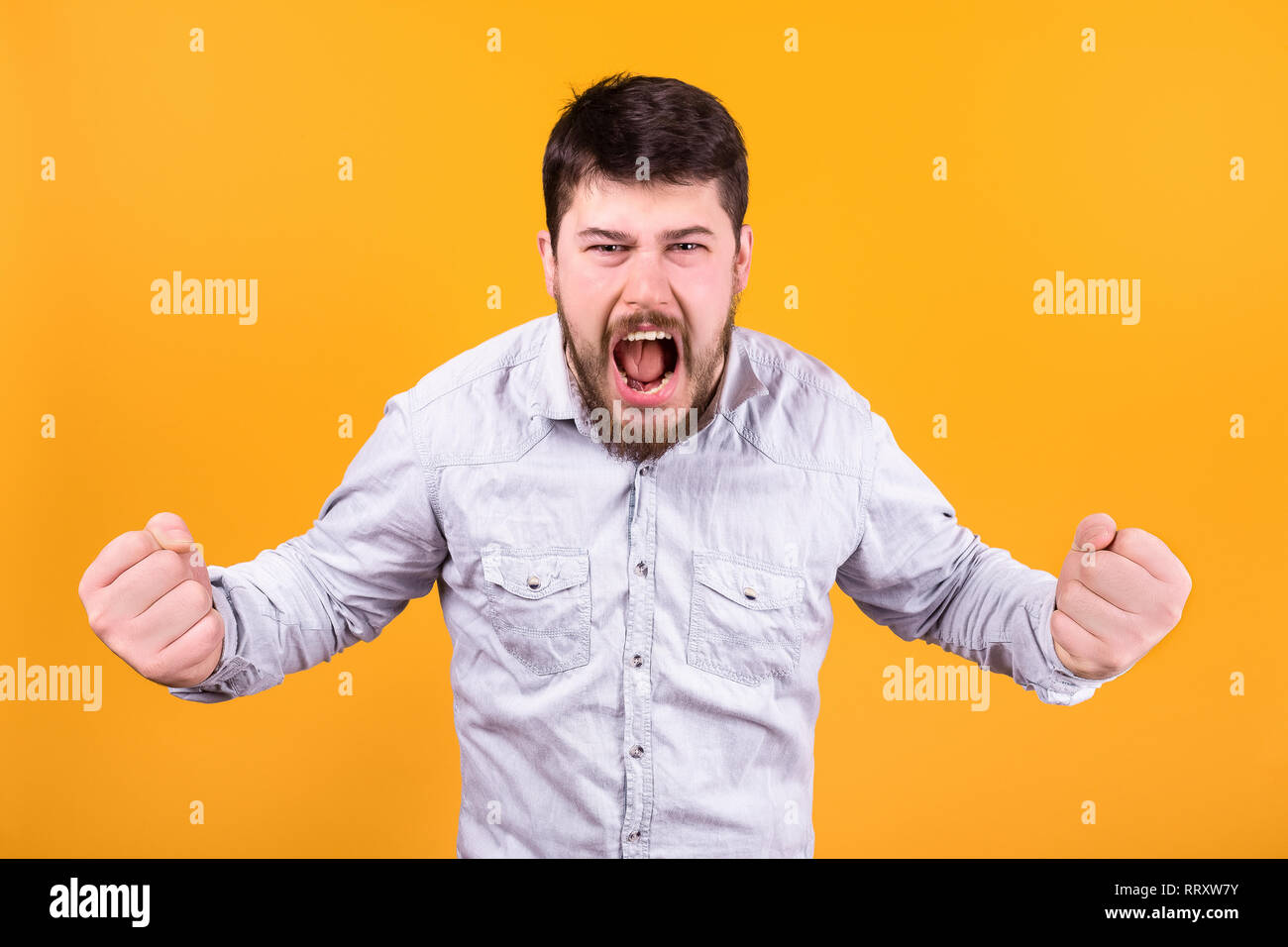 aggressive man screaming clenched fists on orange background Stock ...