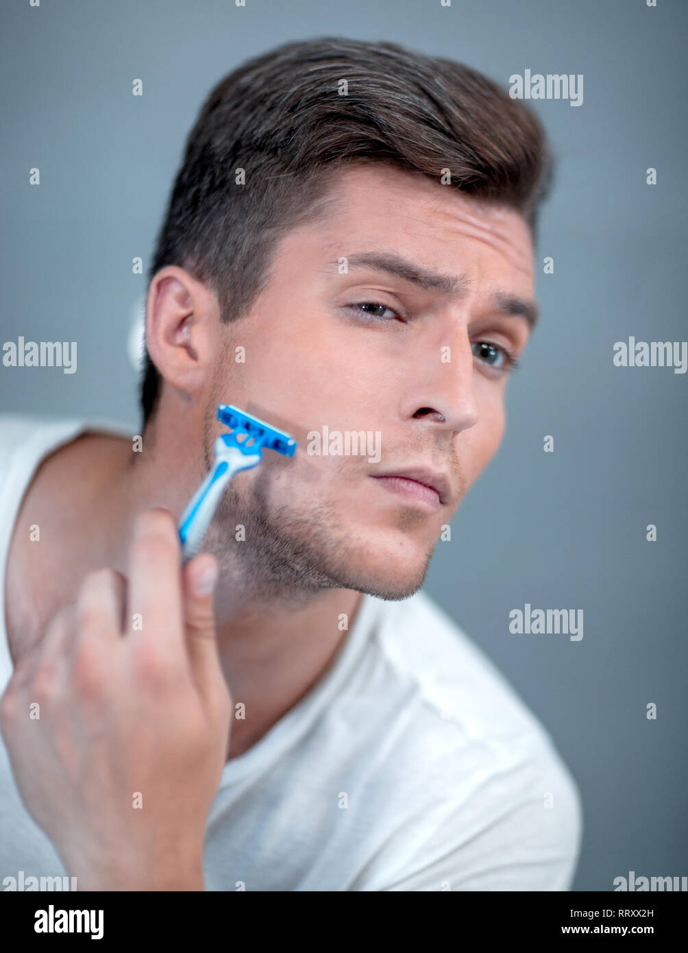 close up. stylish modern guy shaves his face Stock Photo - Alamy