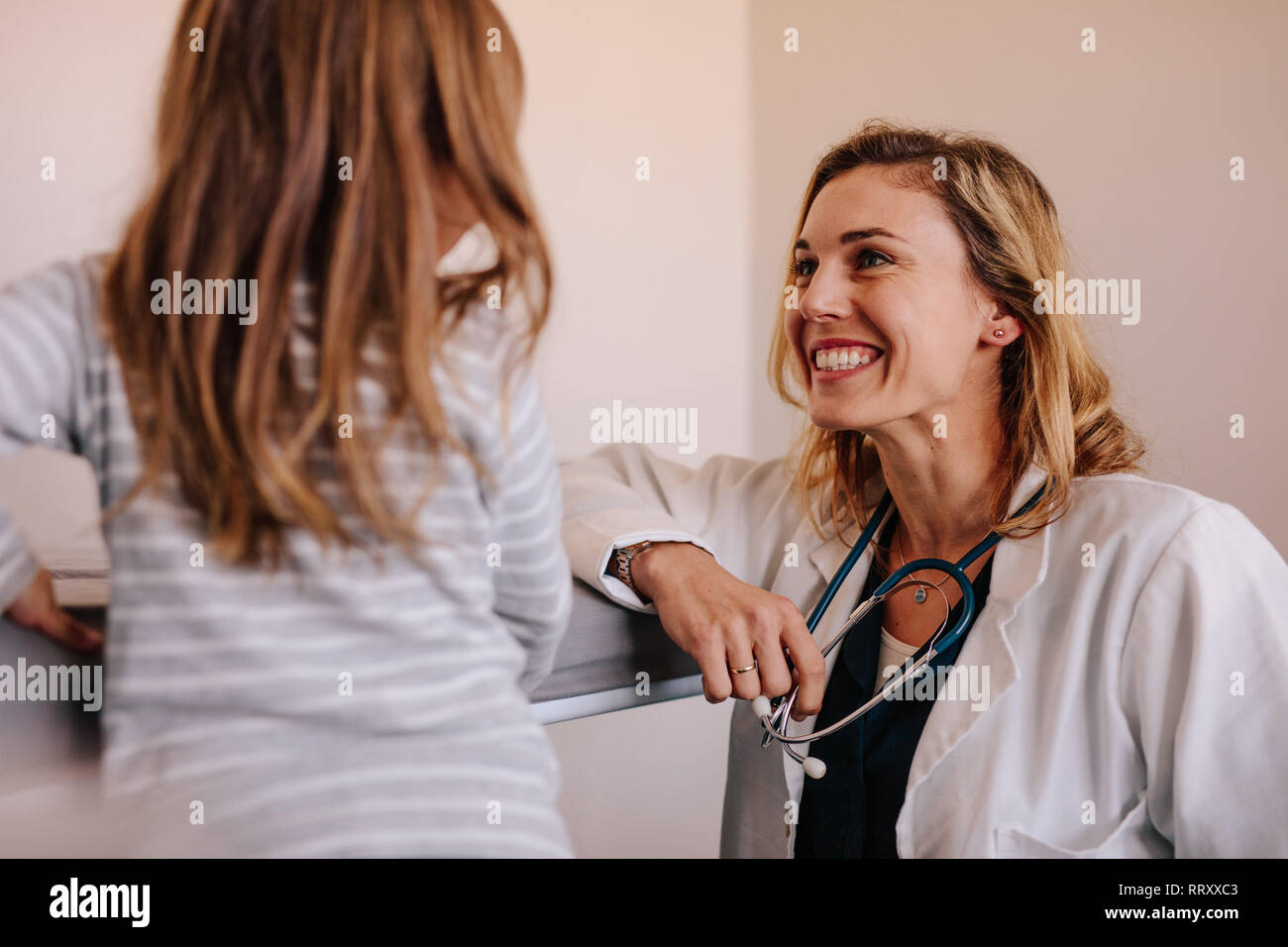 Friendly happy doctor pediatrician with patient child girl in office at ...