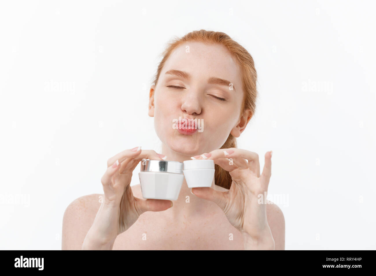 portrait of beautiful woman smiling while taking some facial cream ...