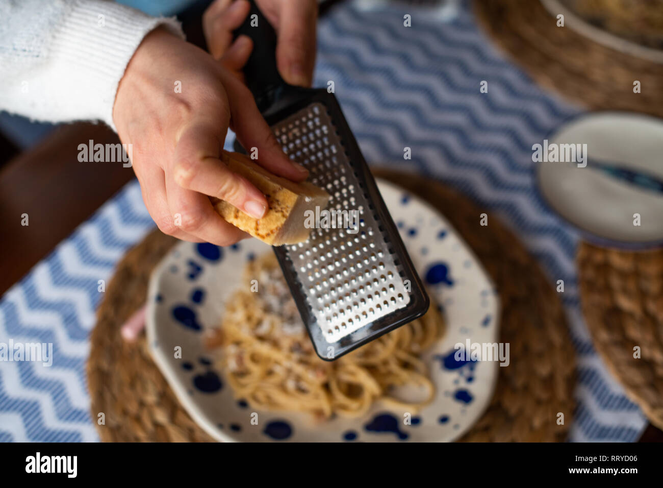 woman hands grating parmesan cheese on pasta carbonara Stock Photo - Alamy