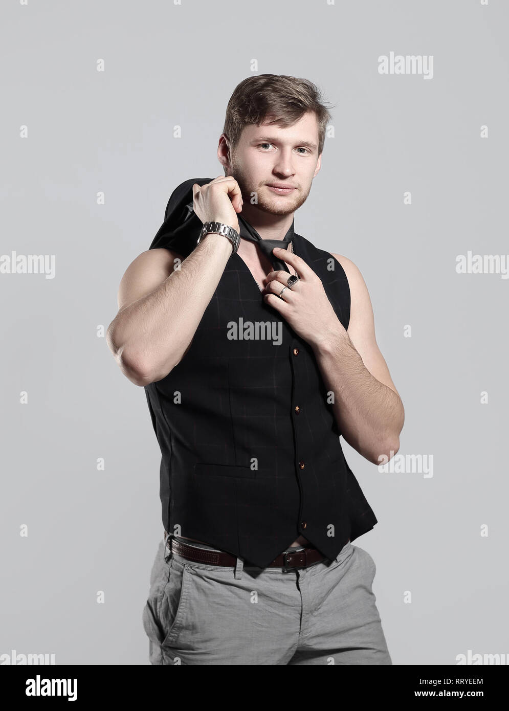 young businessman in a business suit without a shirt takes off his tie ...