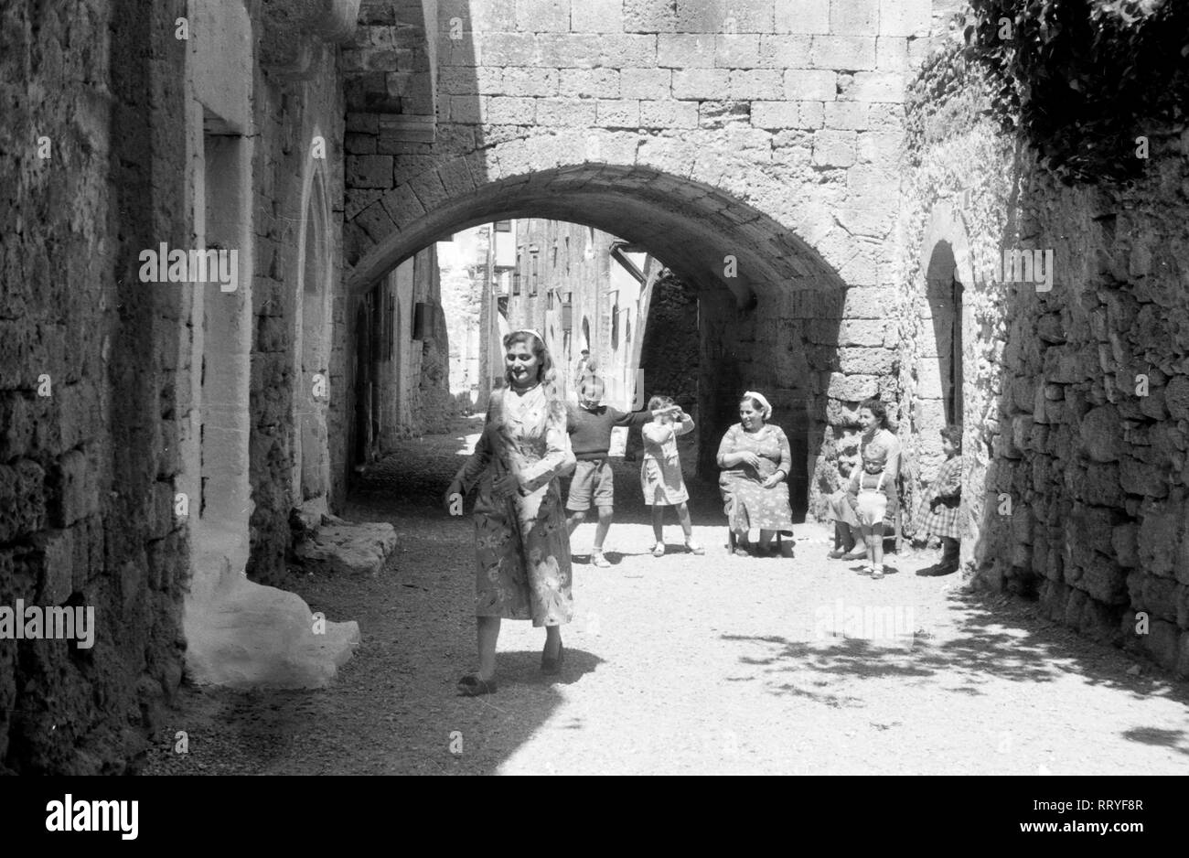 Griechenland, Greece - Kinder spielen in einer sonnigen Gasse, die ...