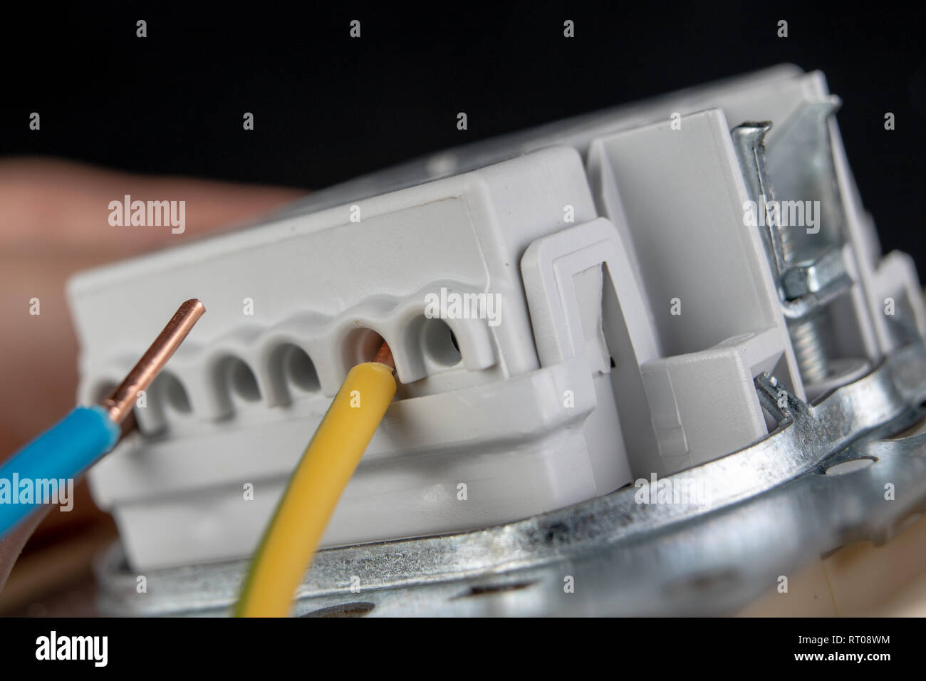 Electrical wires mounted to an electrical outlet. Electrical ...