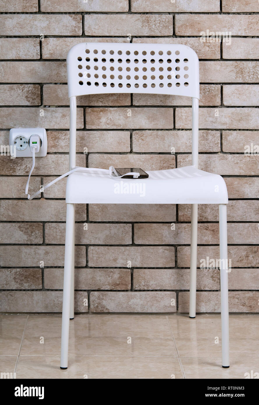 Mobile is charging battery. Phone on the chair Stock Photo - Alamy