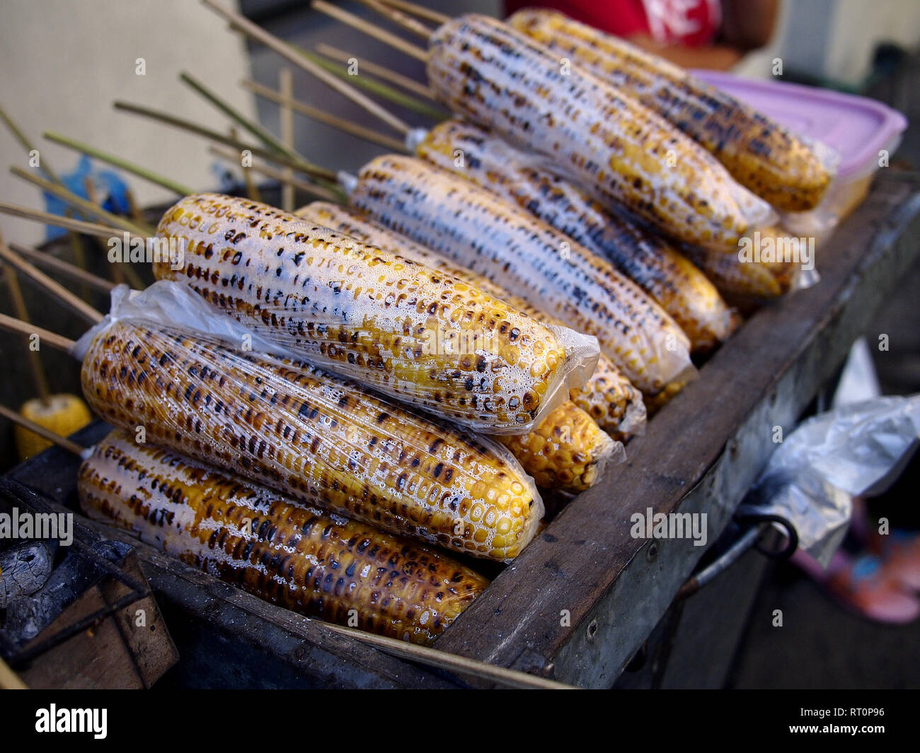 Close up photo of grilled sweet corn on barbecue stick sold at a street ...