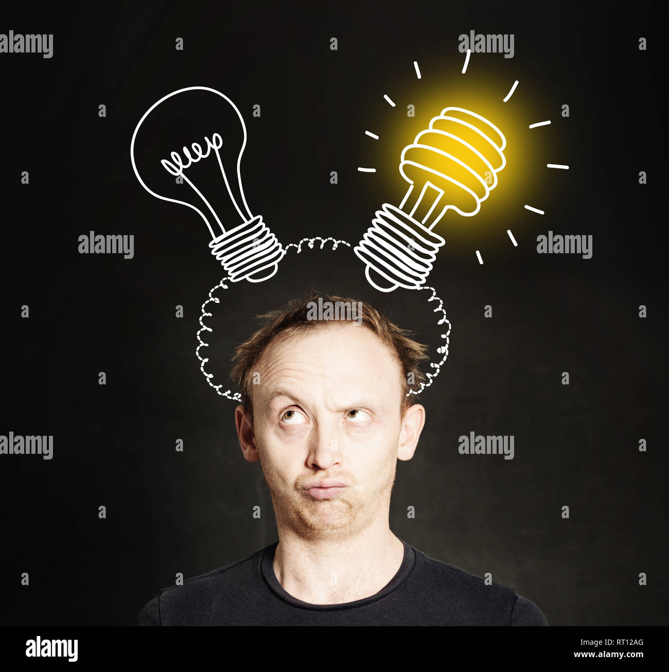 Brainstorm. Man with two light bulb on blackboard background ...