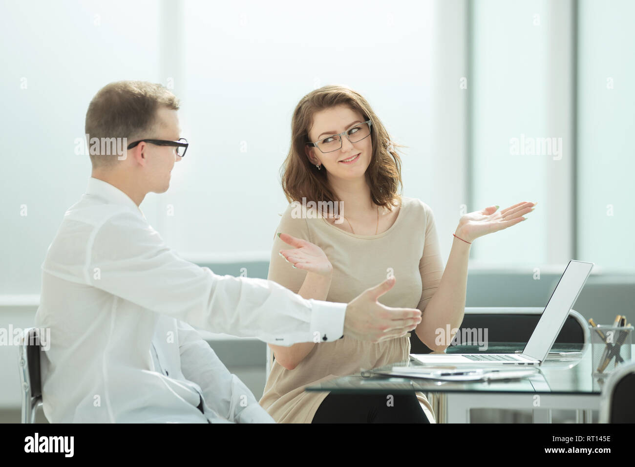 side view. business colleagues discuss something sitting at the Desk ...