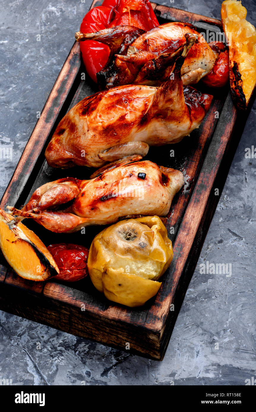 Quail fried with orange and apples.Roasted quail on cutting board Stock ...