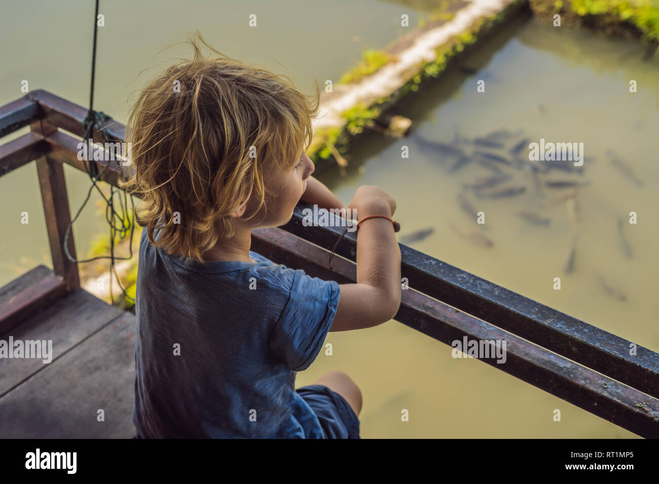 Boy And Girl Sitting By Pond High Resolution Stock Photography and ...