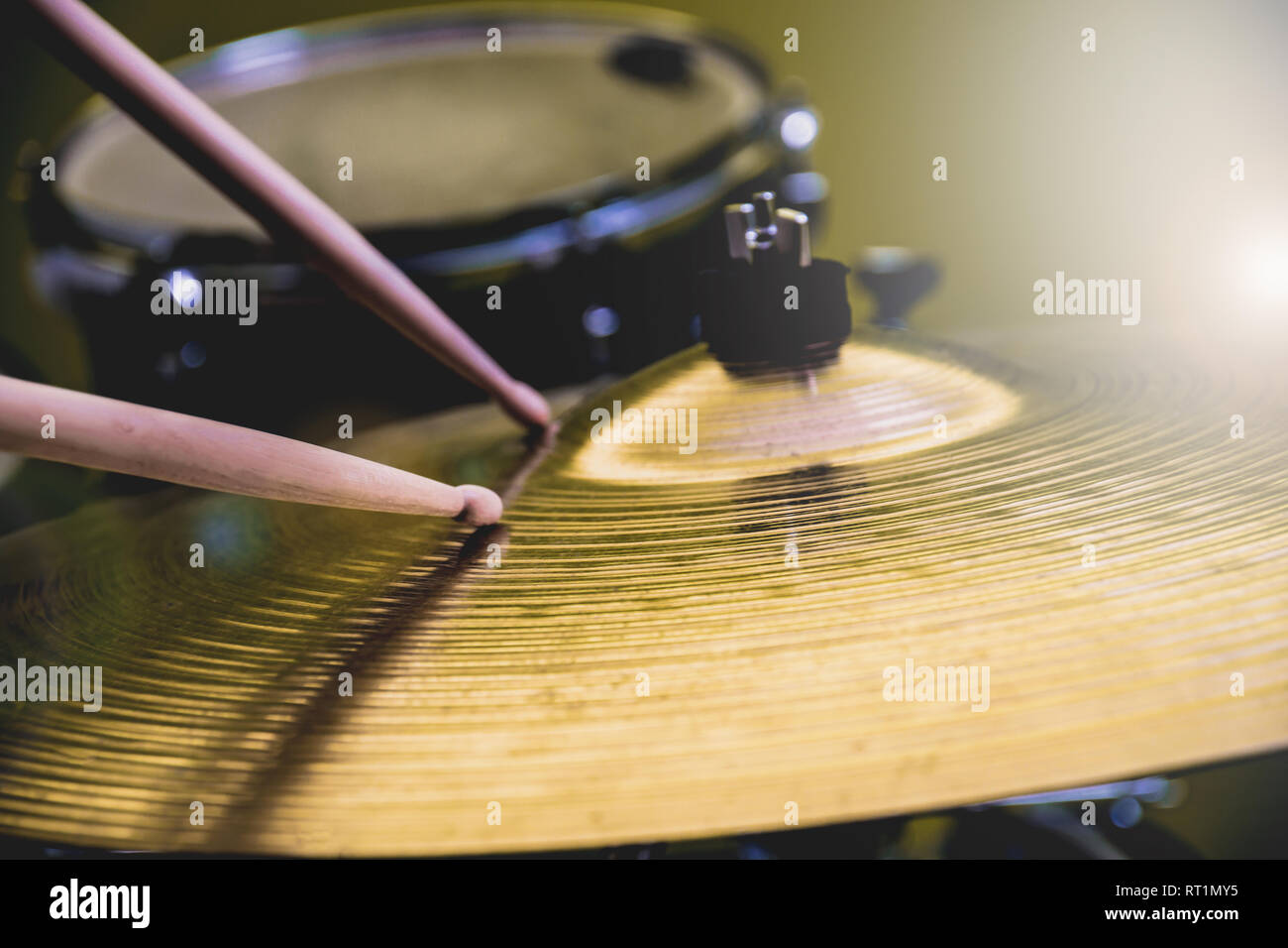 Drumstick splaying on a hi-hat or ride cymbal. Drums kit. Lens flare ...