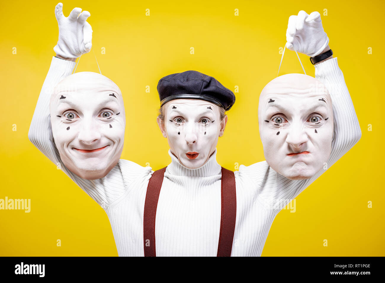 Portrait of a pantoomime holding two facial masks with different ...