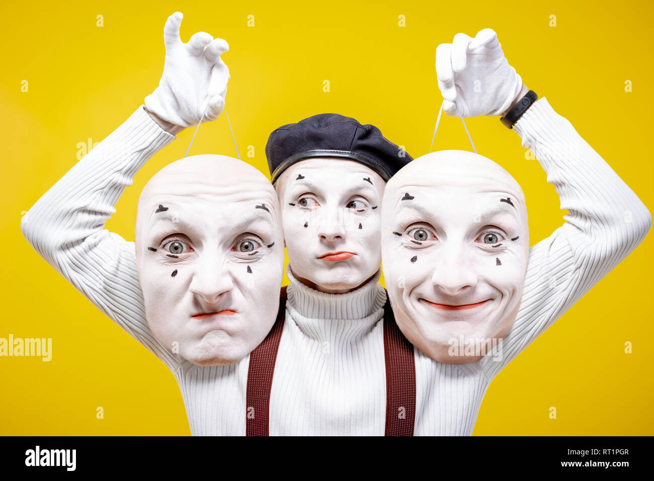 Portrait of a pantoomime holding two facial masks with different ...