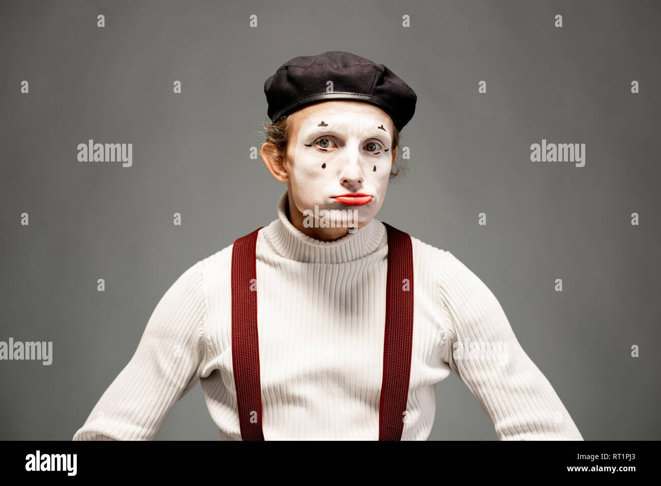 Portrait of a pantomime actor with white facial makeup posing with ...