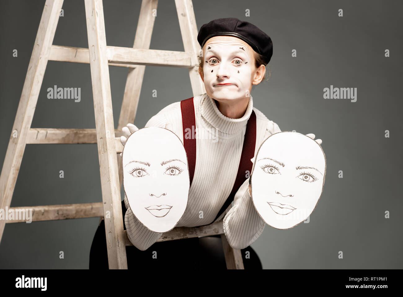 Portrait of a pantoomime actor holding facial masks in the studio with ...