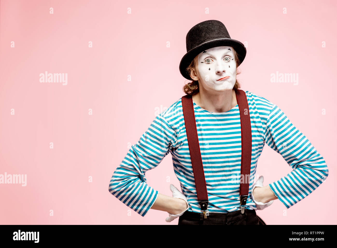 Portrait of an actor as a pantomime with white facial makeup posing ...