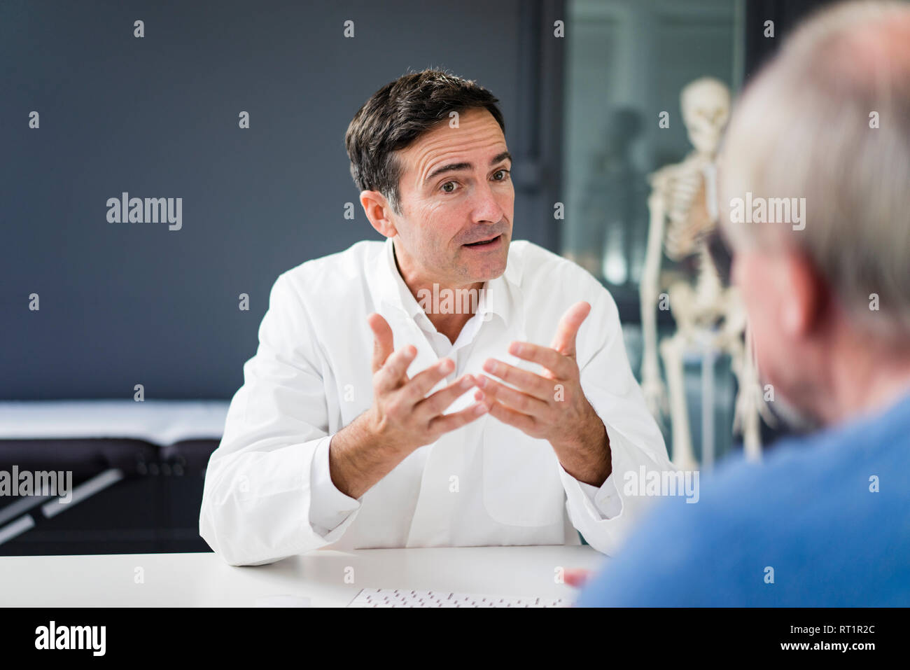 Doctor talking to patient in medical practice Stock Photo - Alamy