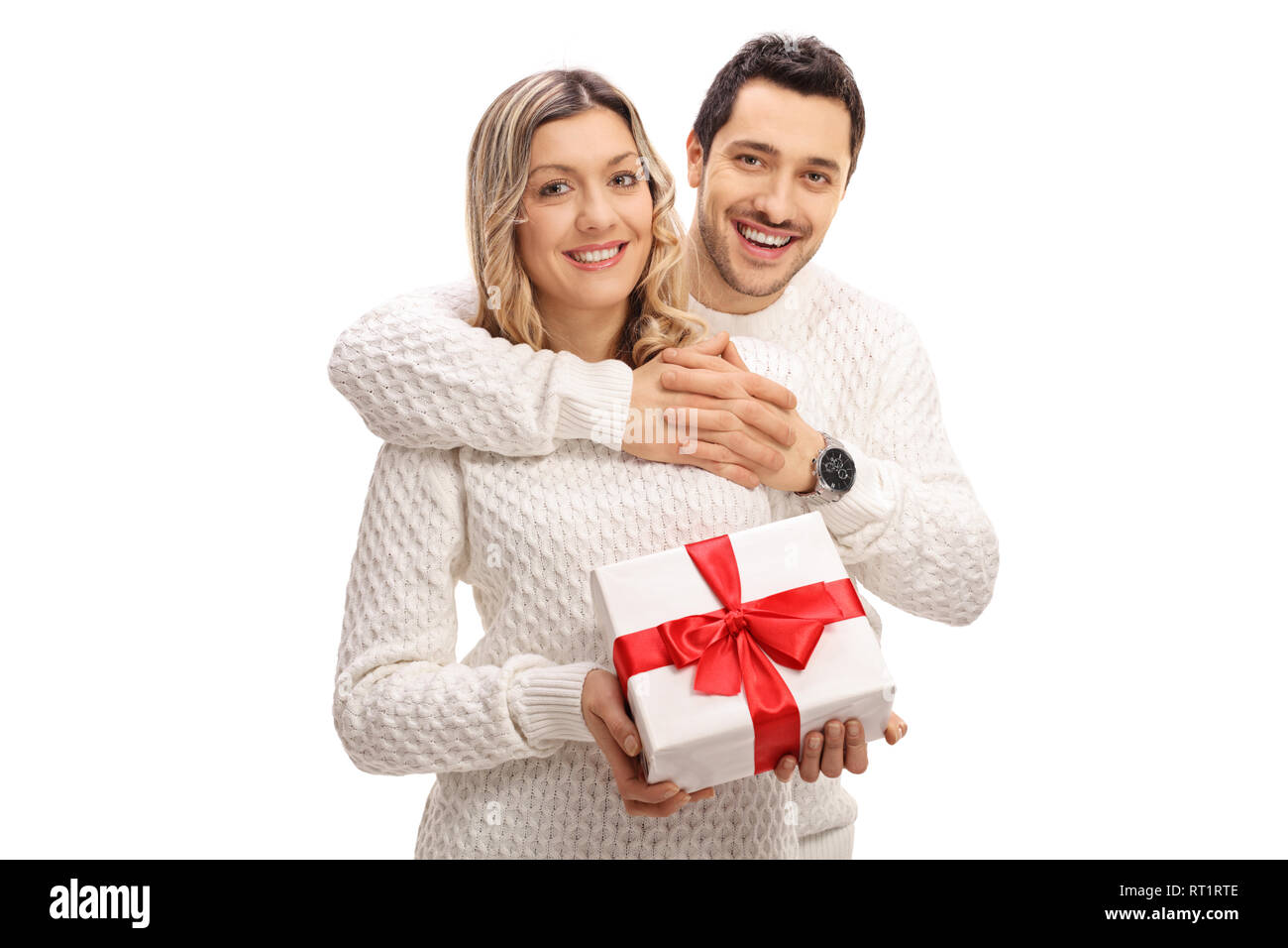 Young man hugging a young woman holding a wrapped gift box isolated on ...