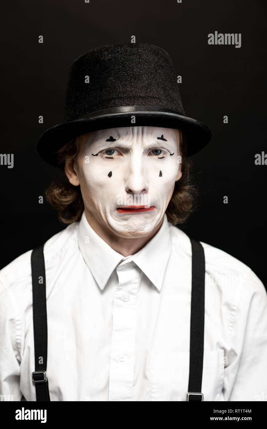Close-up portrait of a pantomime with white facial makeup posing with ...