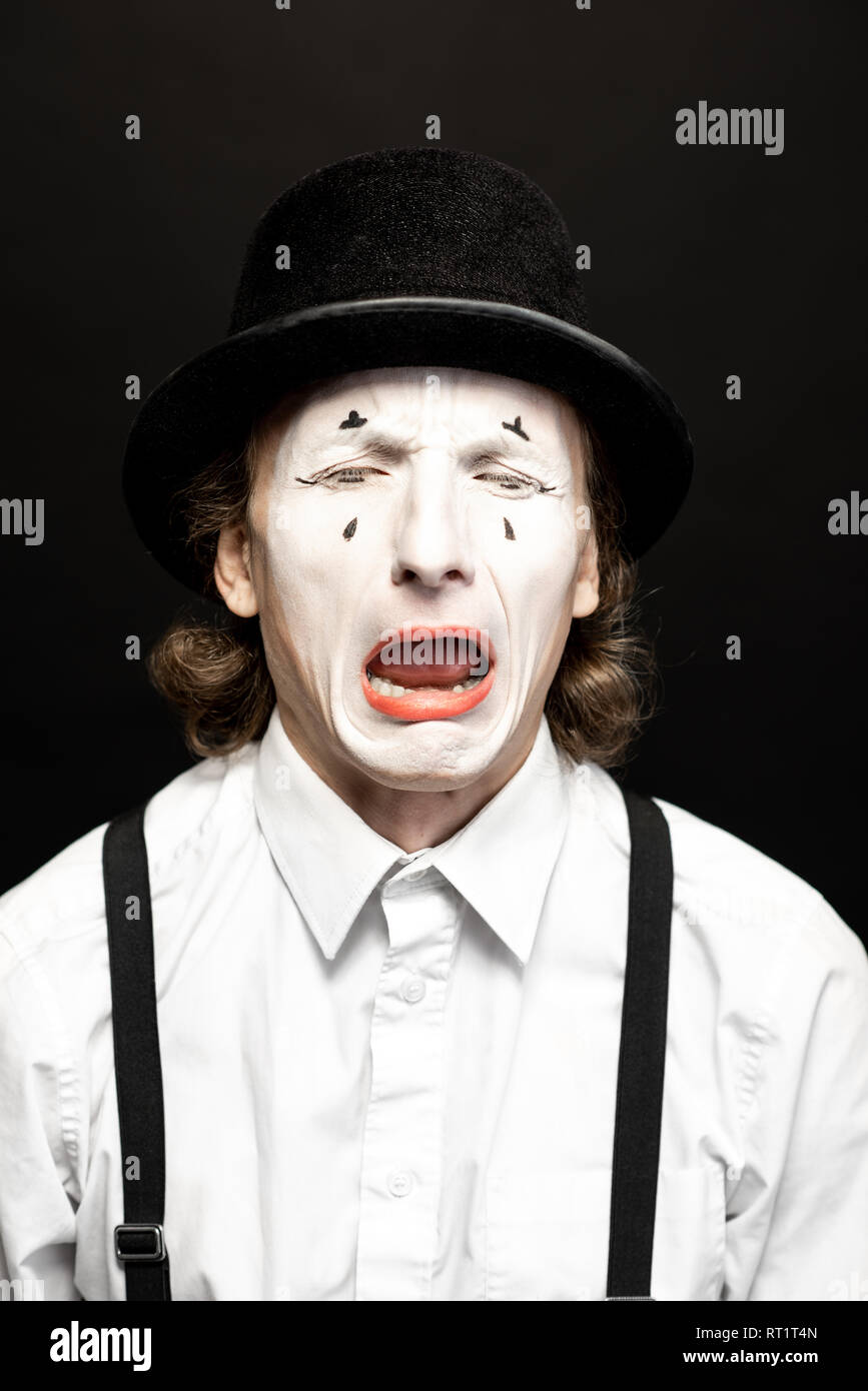 Close-up portrait of a pantomime with white facial makeup posing with ...