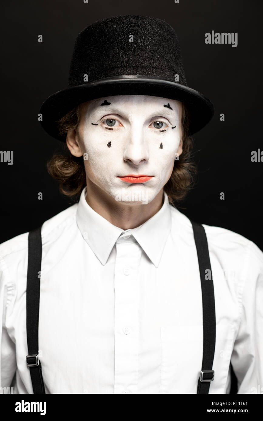Close-up portrait of a pantomime with white facial makeup posing with ...