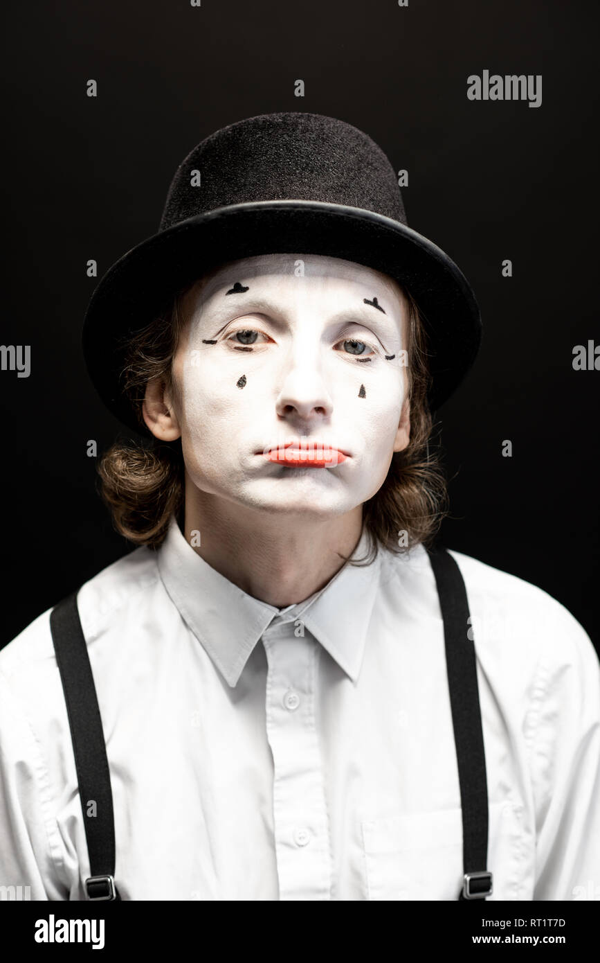 Close-up portrait of a pantomime with white facial makeup posing with ...