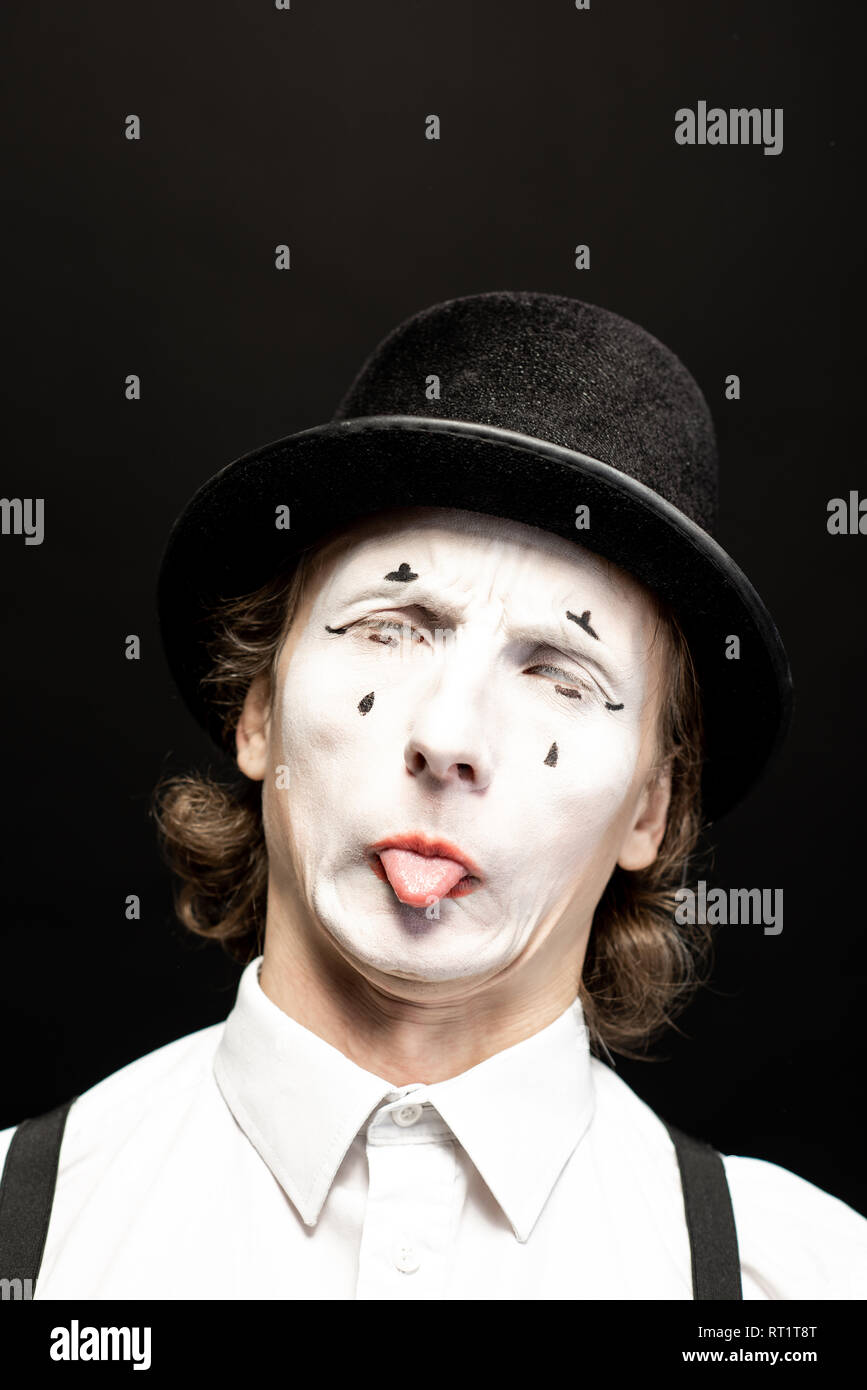 Close-up portrait of a pantomime with white facial makeup posing with ...