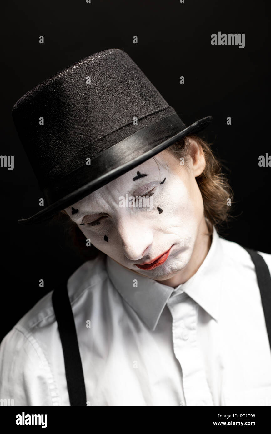 Close-up portrait of a pantomime with white facial makeup posing with ...