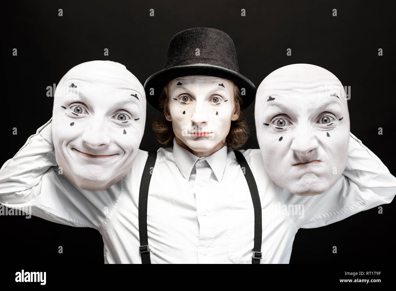 Portrait of a pantoomime holding two facial masks with different ...