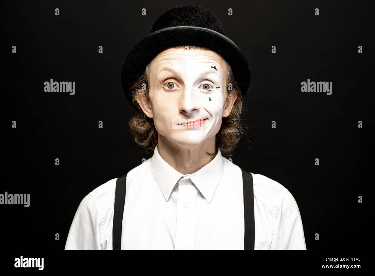 Portrait of a pantomime with a make-up on the one side of his face on ...