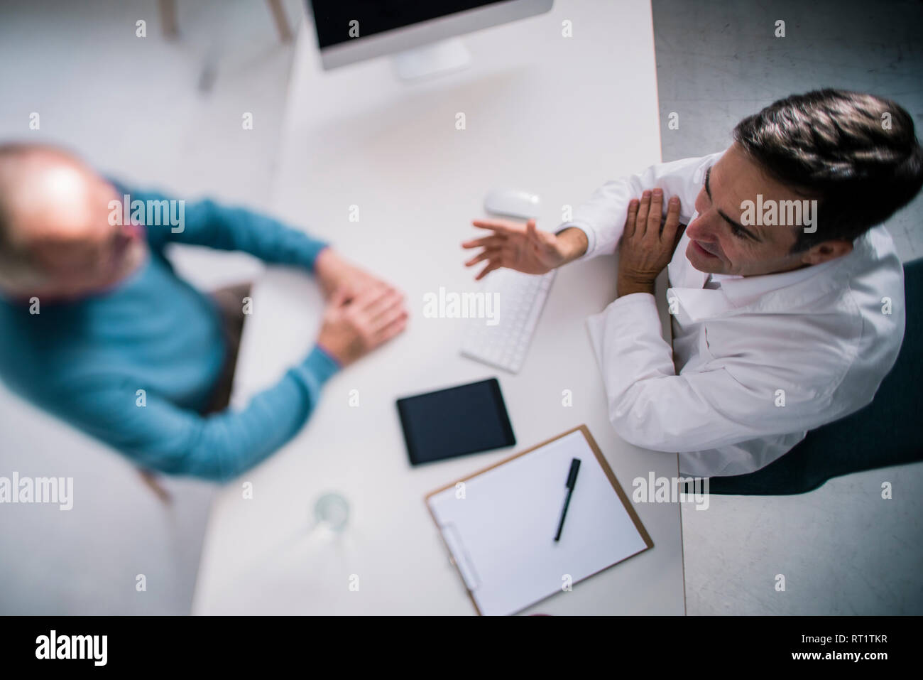 Top view of doctor talking to senior patient in medical practice Stock ...