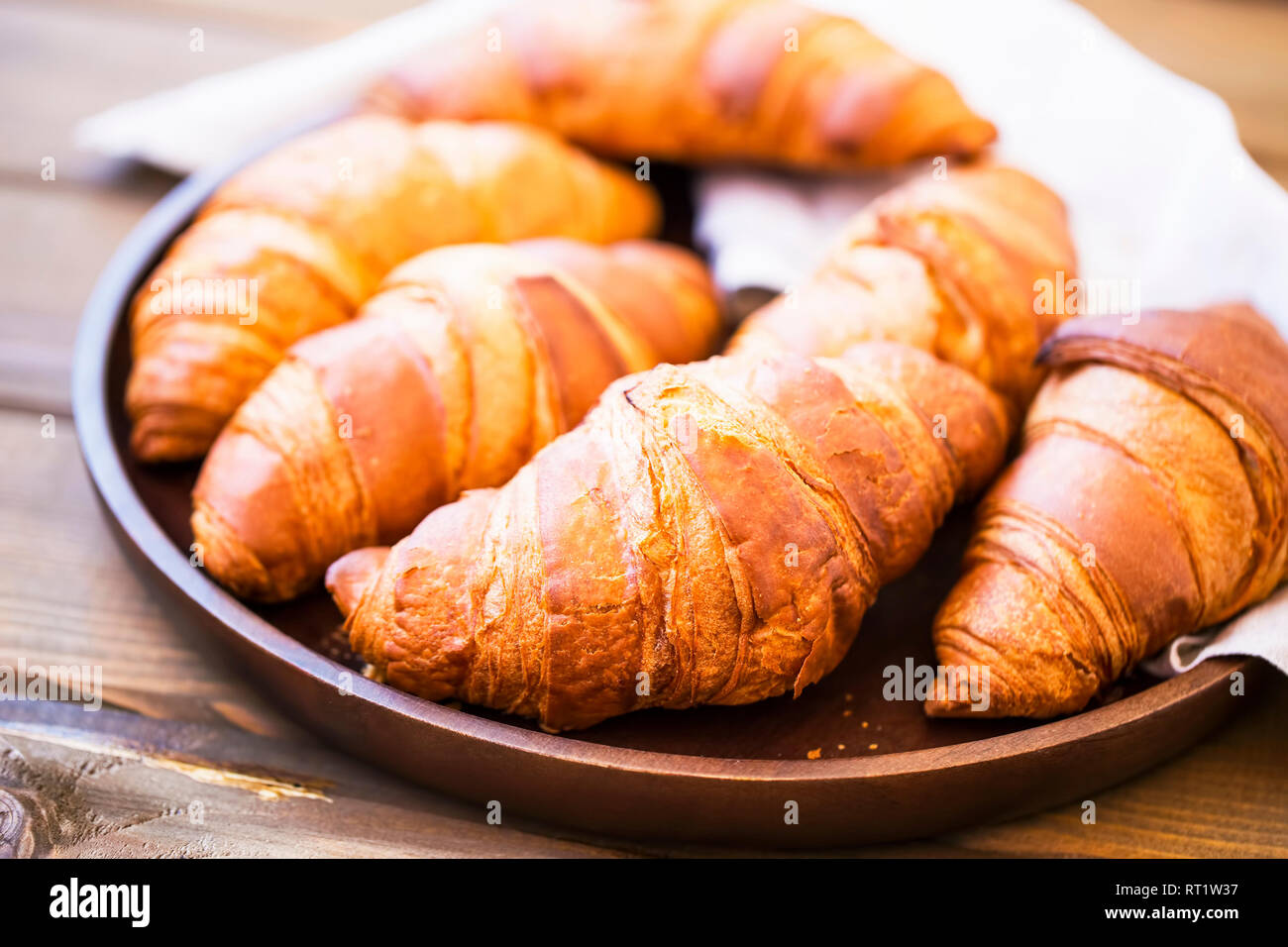 Fresh croisssants buns heap in wooden tray, french croissants, fresh crusty breakfast croissants ...