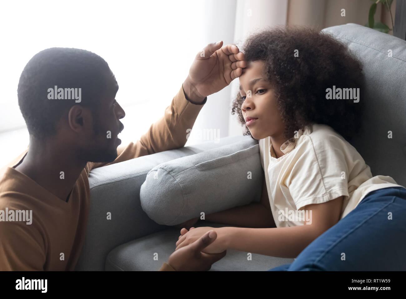 Caring african father touching forehead of ill kid daughter Stock Photo ...