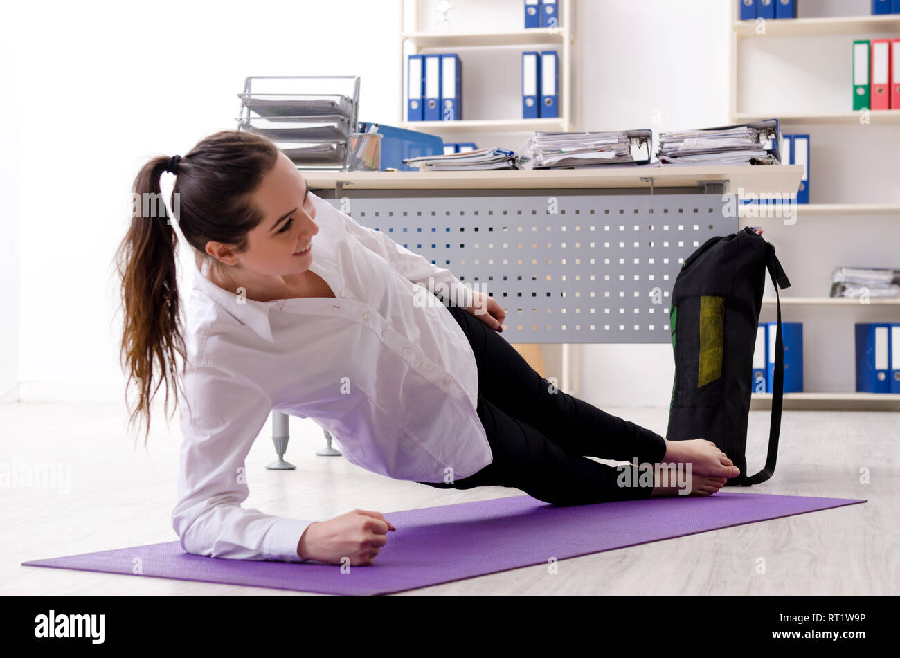 Female employee doing sport exercises in the office Stock Photo - Alamy