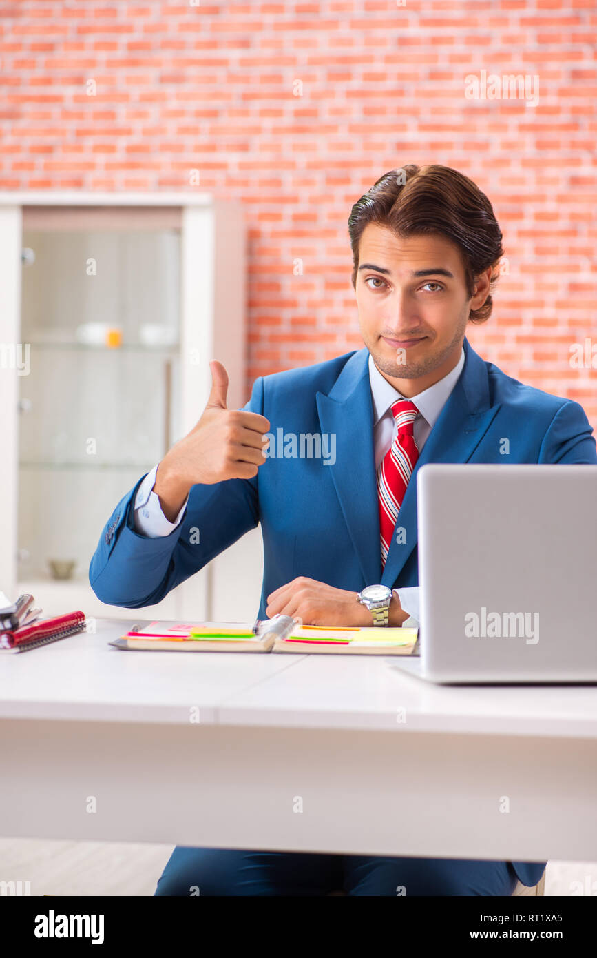 Young handsome employee working in the office Stock Photo - Alamy