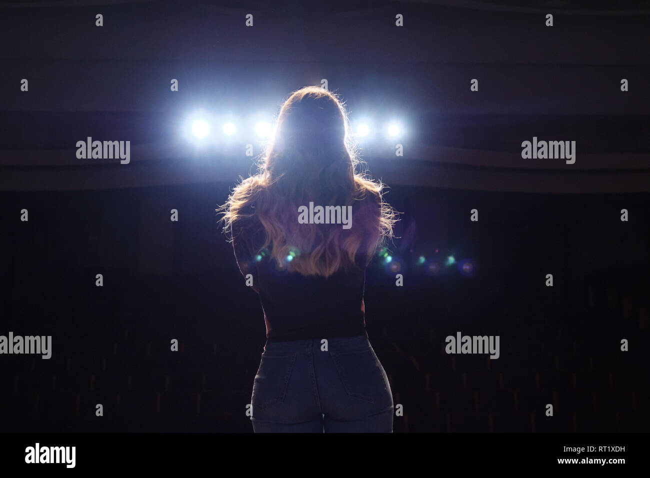 unrecognizable singer standing on stage at microphone in night club ...