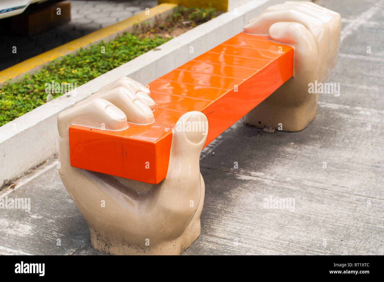 A bench with hands sculpture in the sidewalk Stock Photo - Alamy