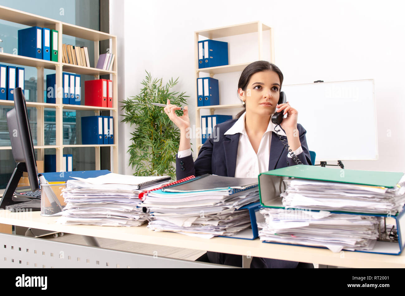 Female employee with too much work in the office Stock Photo - Alamy