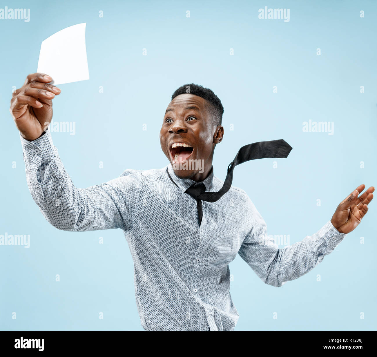 Young afro man with a surprised happy expression won a bet on blue ...