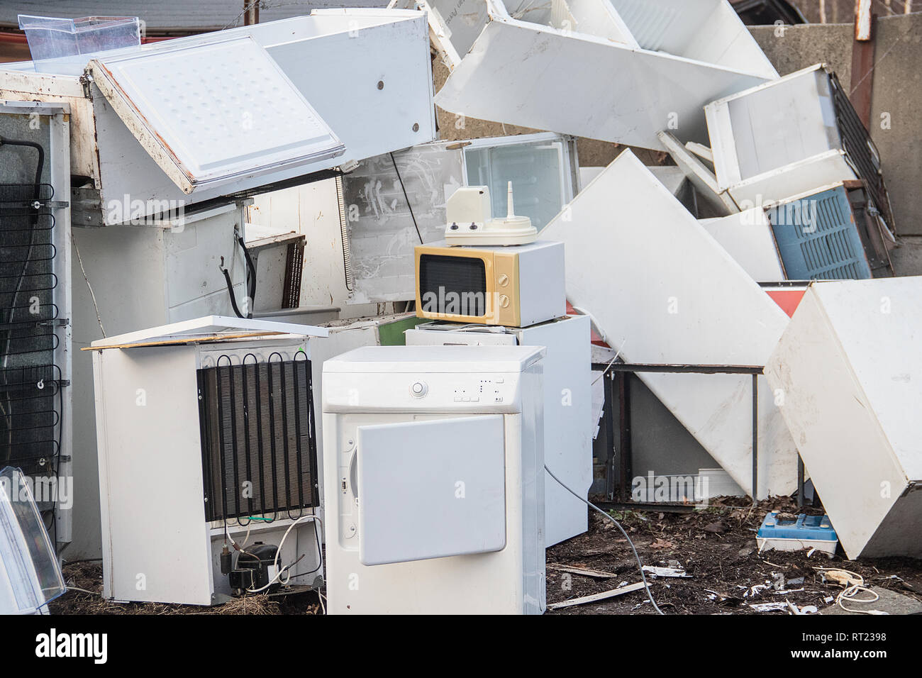 A stack of old white electrical household appliances waste such as a ...
