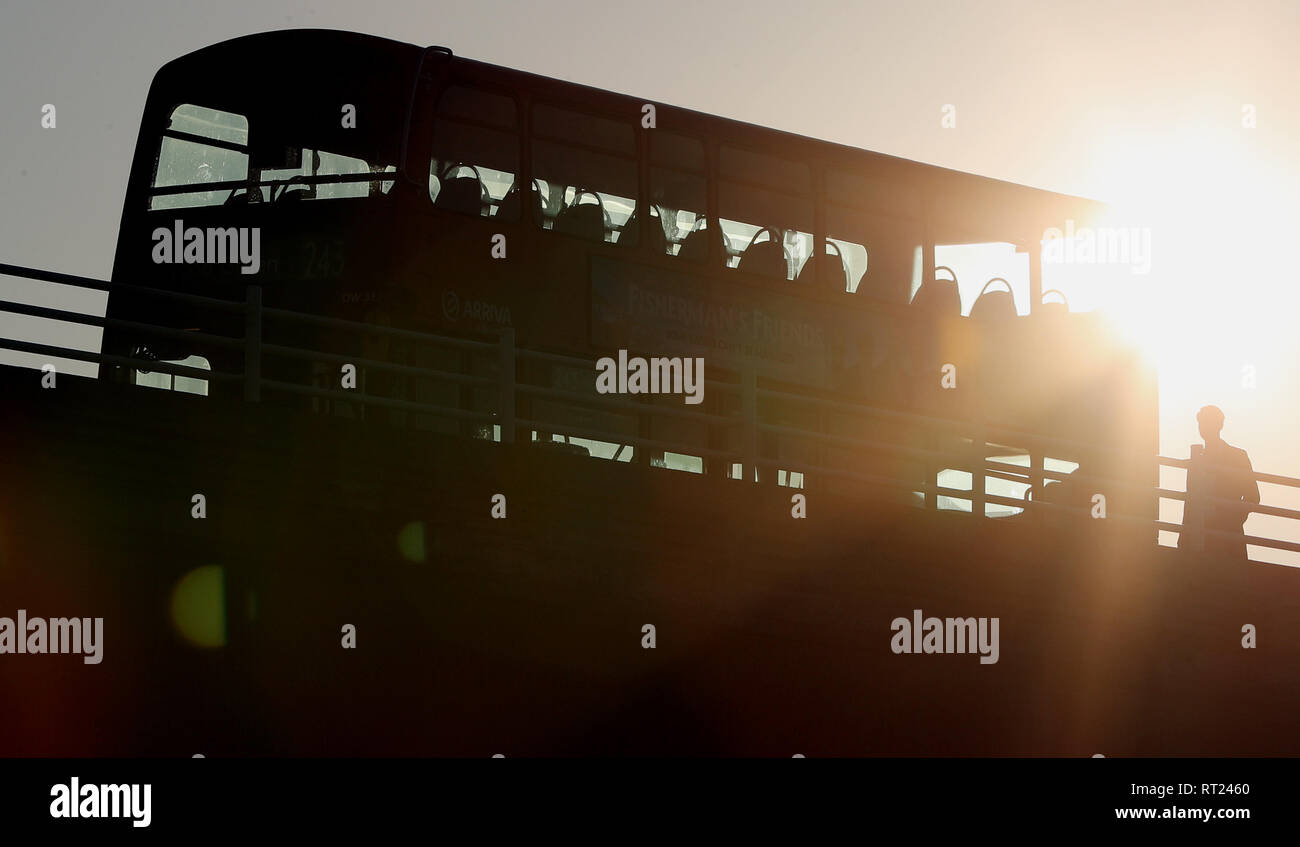 A pedestrian passes a double decker bus on London's Waterloo Bridge, as ...