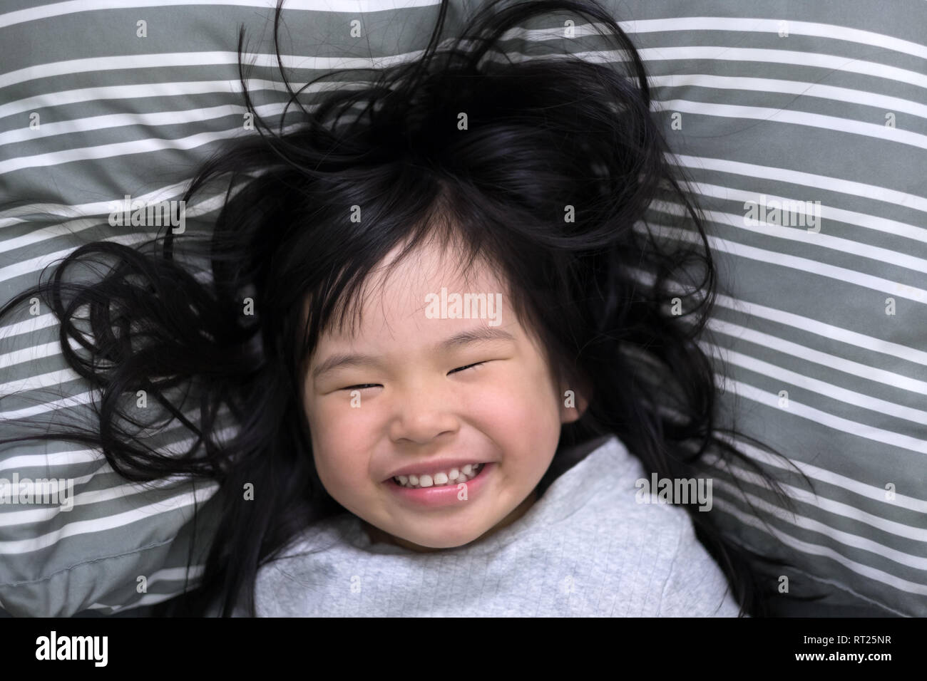 Young girl wakes up in the morning smiling Stock Photo - Alamy