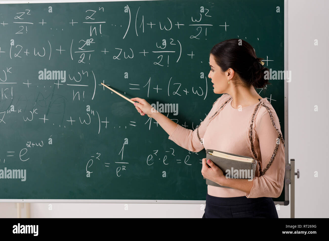 Female teacher standing in front of chalkboard Stock Photo - Alamy