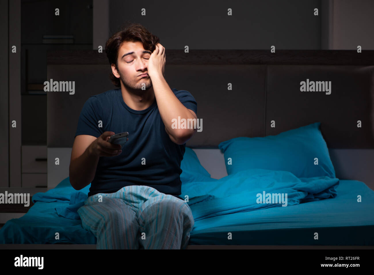 Man watching tv at night in bed Stock Photo - Alamy