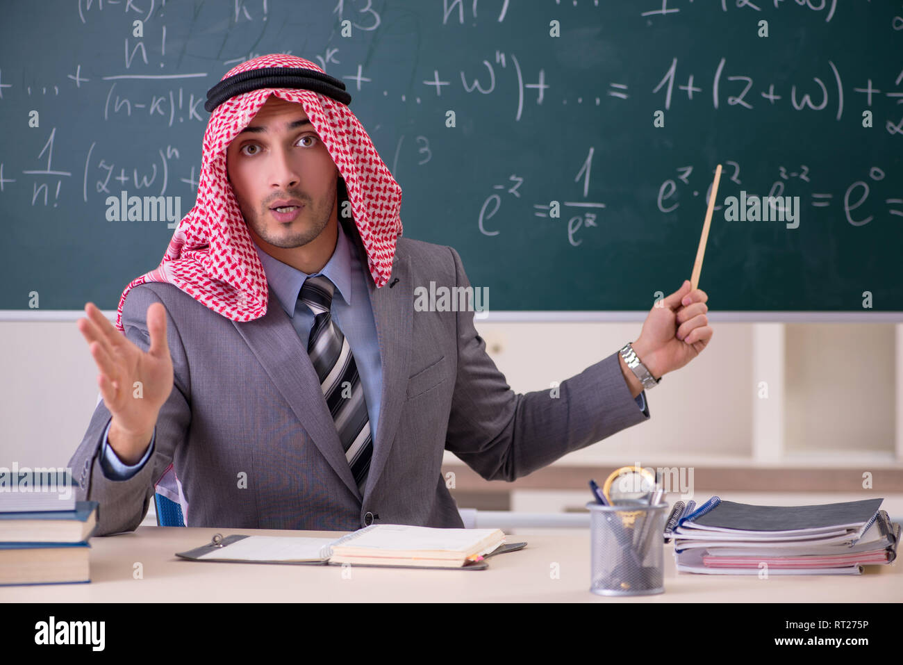 Arab teacher wearing suit in front of chalkboard Stock Photo - Alamy