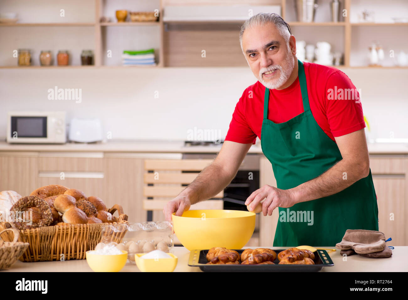 Old male baker working in the kitchen Stock Photo - Alamy